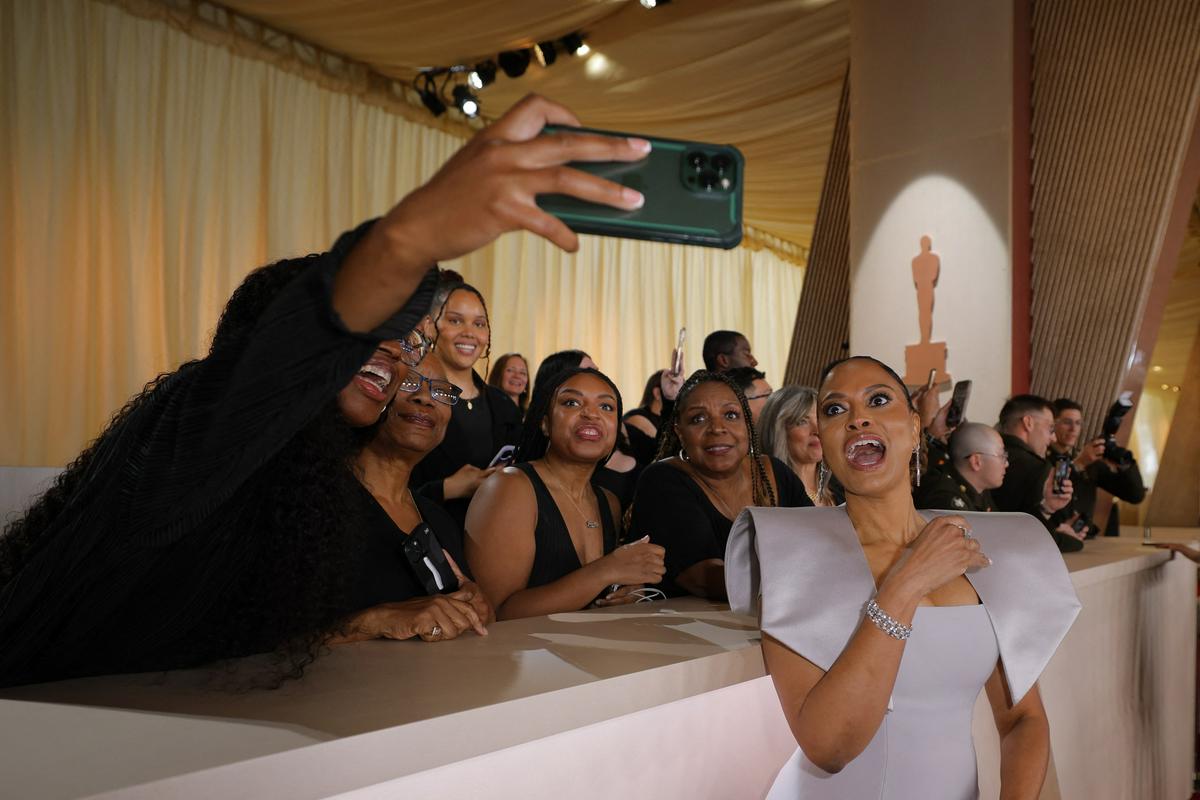 Umetelno okrašeni nohti, narobe obrnjena verižica, ogledalca na obleki in Ariana kot lestenec ...